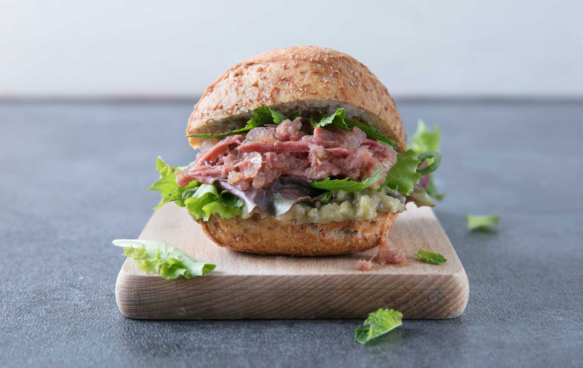 Panino integrale con Simmenthal, crema di melanzane e foglie di menta ...